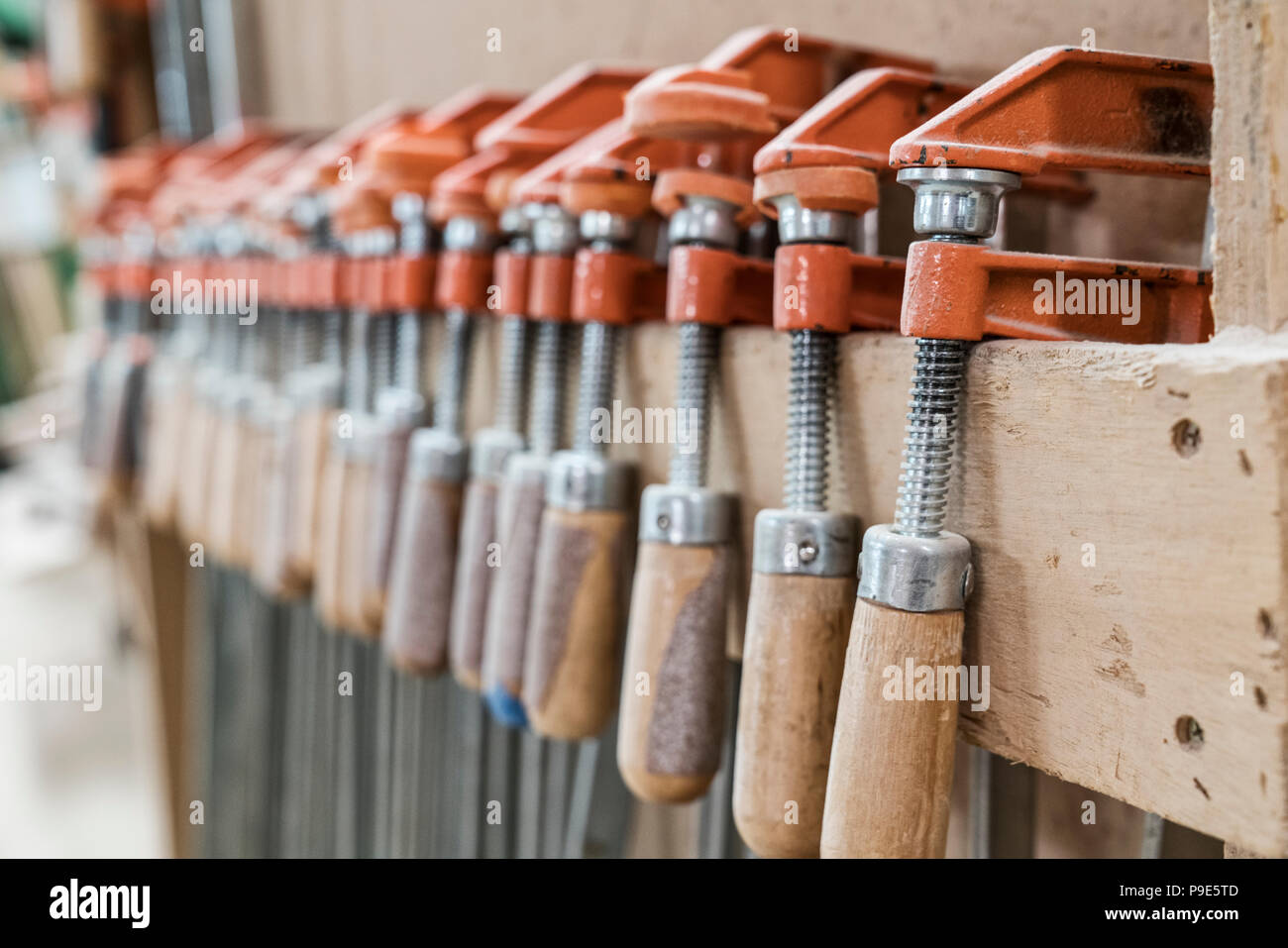 Close up of small bar clamps being used in a woodworking factory Stock ...