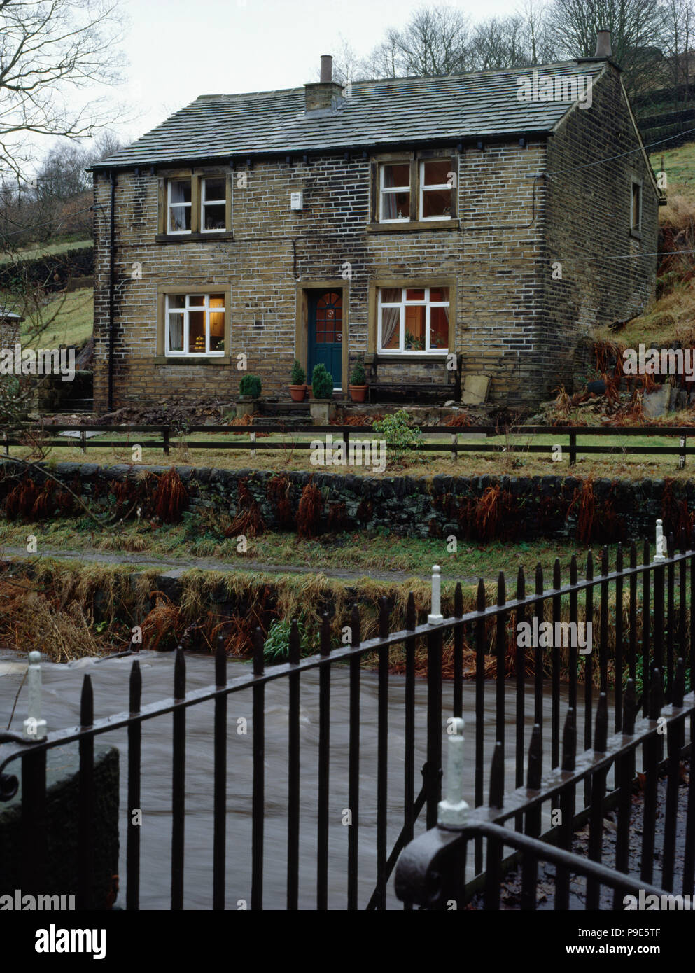 Metal railings on bridge above stream to country cottage Stock Photo ...