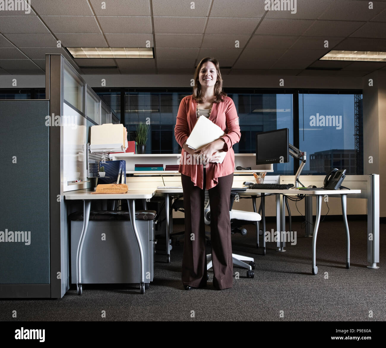 Portrait of a Caucasian woman standing in her cubicle office space ...