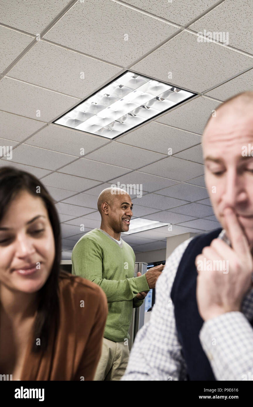 Mixed race team of three people working on a project in an office ...