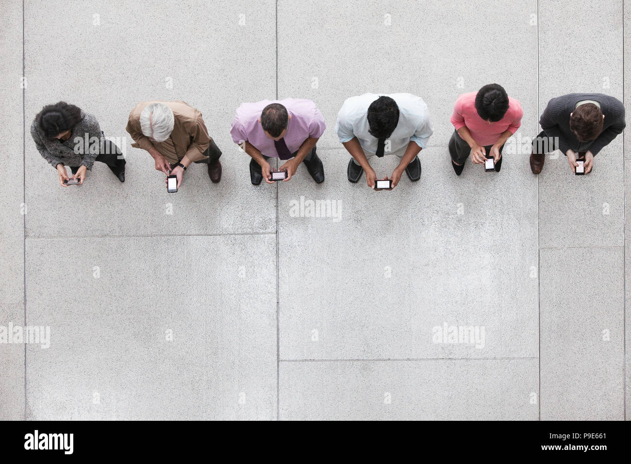 View looking down on a group of business people in a lobby area using ...
