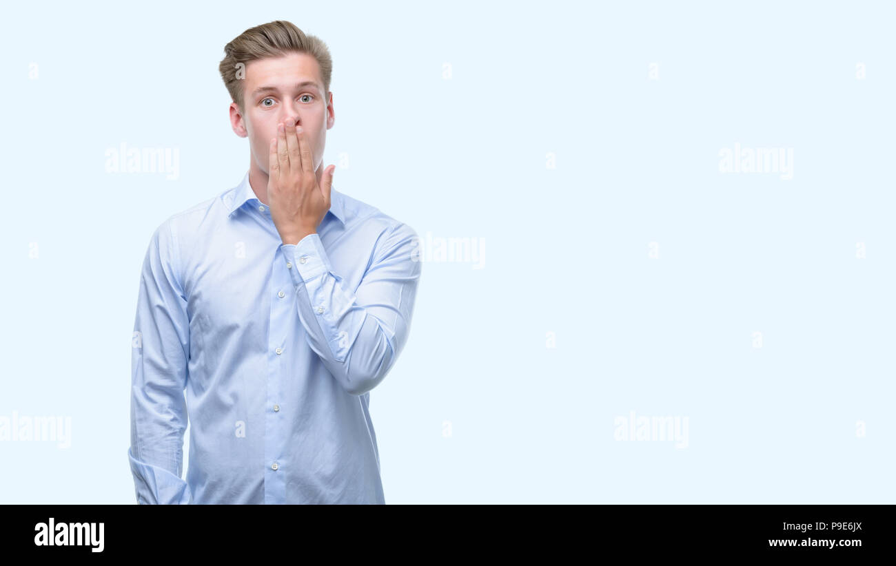 Young handsome blond man cover mouth with hand shocked with shame for ...