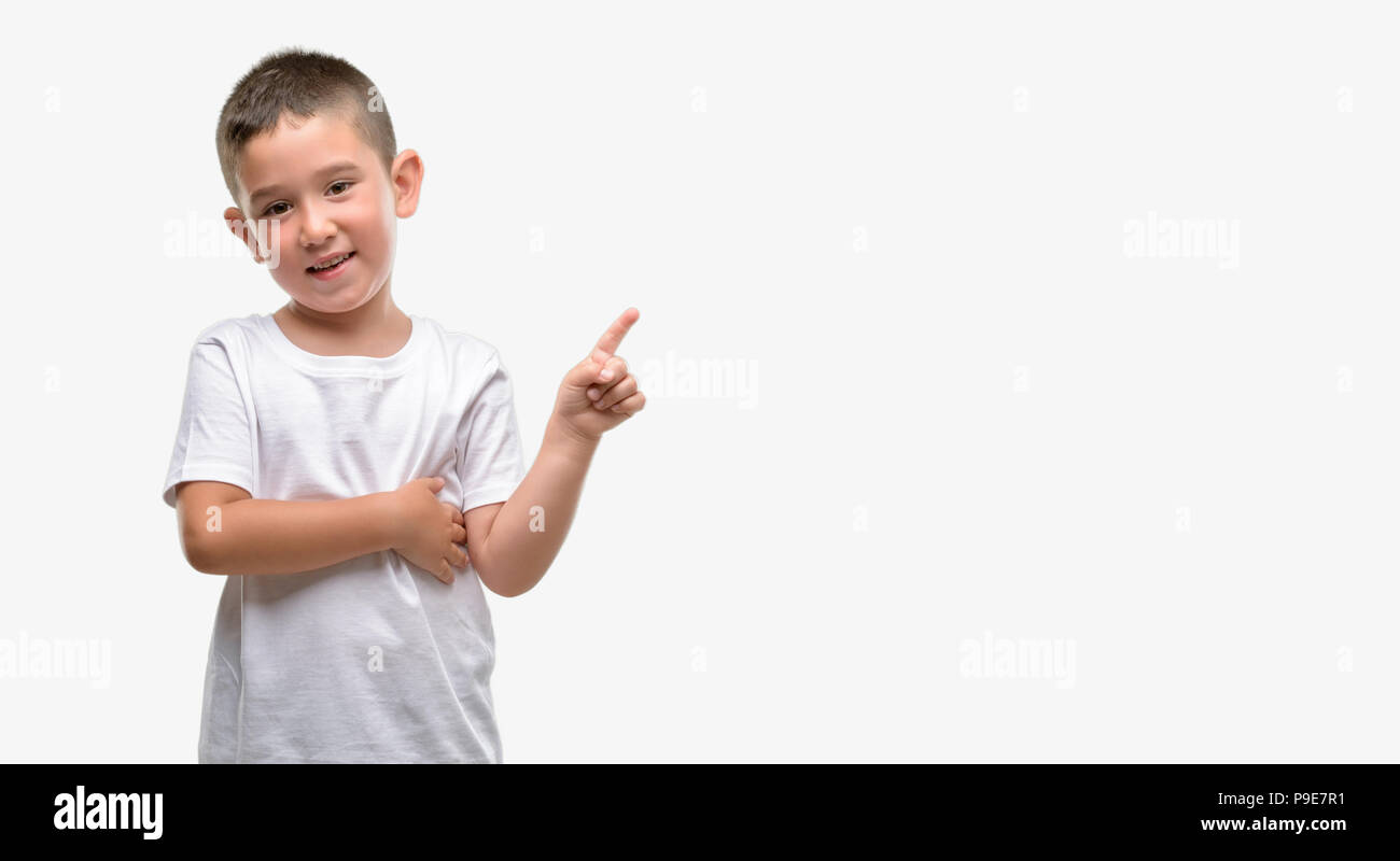 Dark haired little child very happy pointing with hand and finger to ...