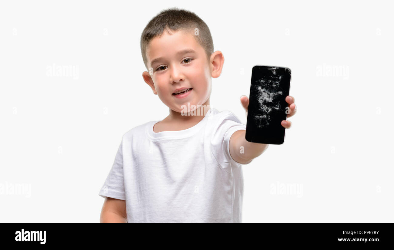 Dark haired little child holding broken smartphone with a happy face ...