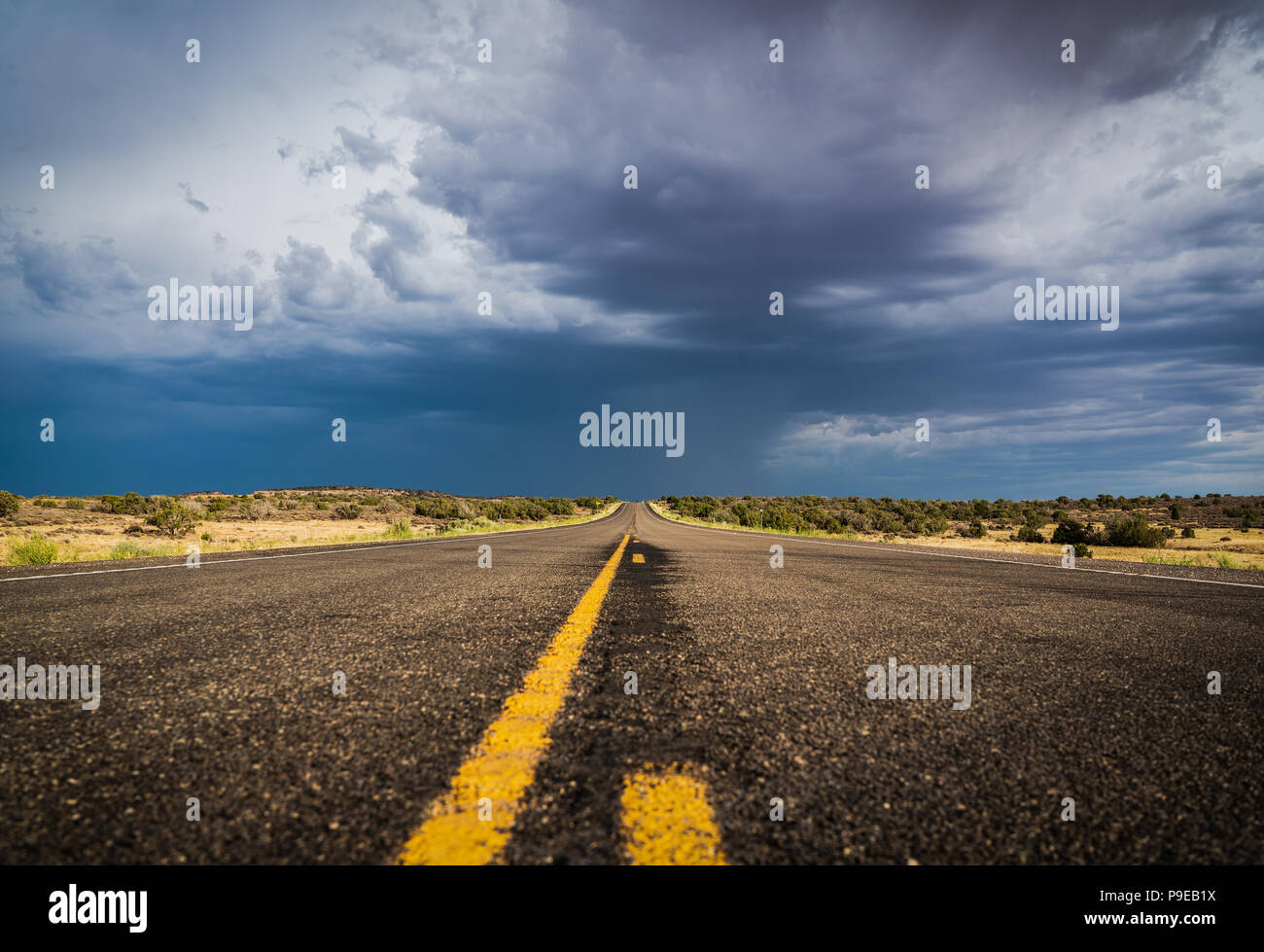Dark skies over a long straight road Stock Photo - Alamy
