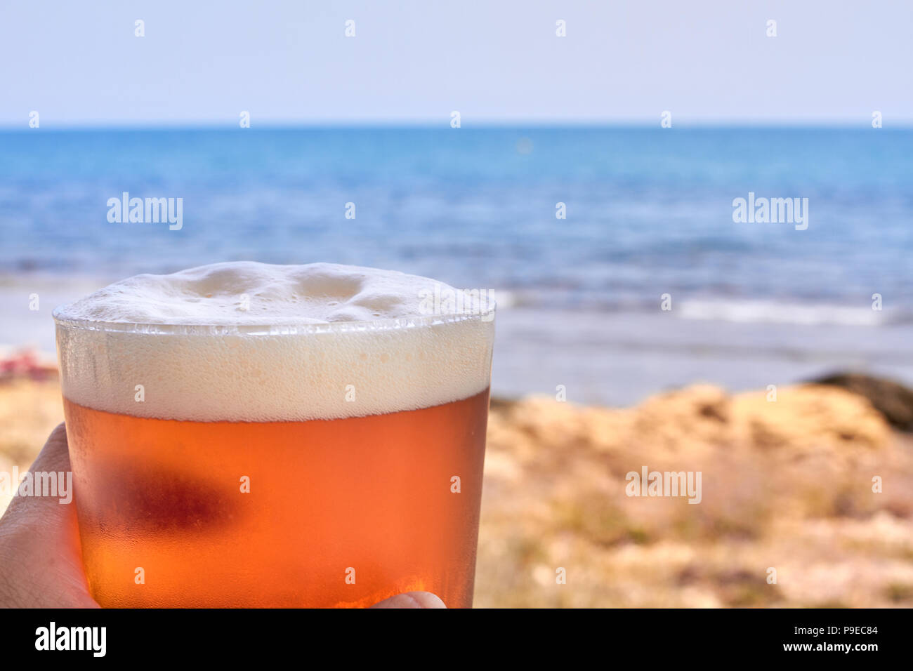 holding a beer in the beach Stock Photo - Alamy