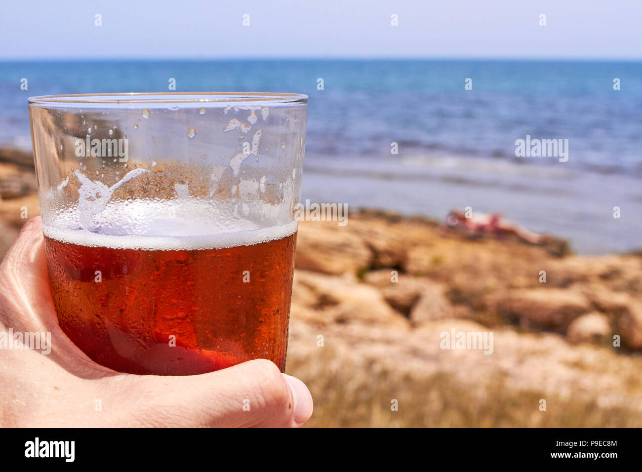 holding a beer in the beach Stock Photo - Alamy