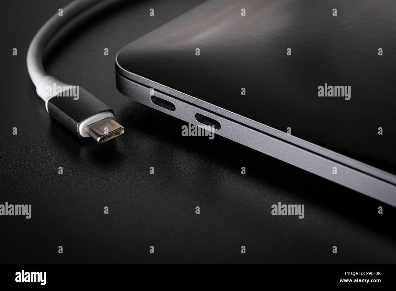 One USB type C cable disconnected from laptop computer on black ...