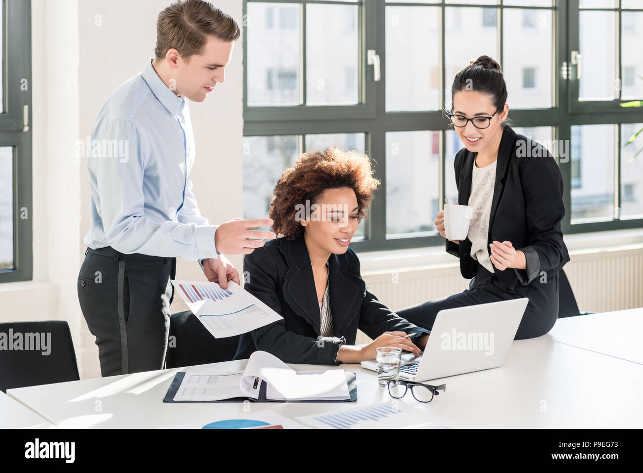 Employees checking together documents and business reports Stock Photo ...