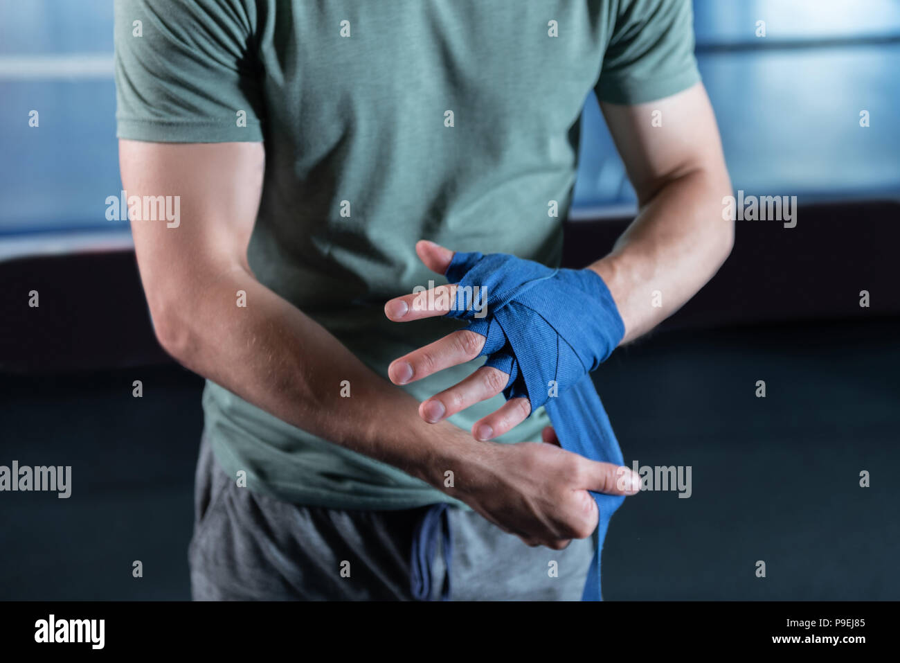 Muscle man rolling his hands in wrist wraps before training Stock Photo ...
