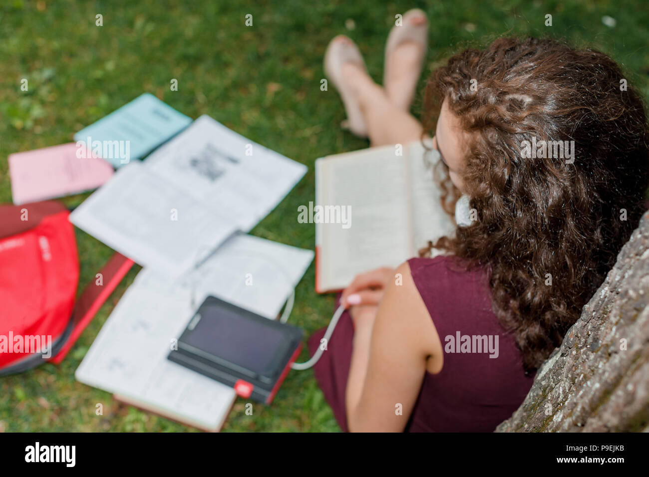 Girl sitting under tree studying hi-res stock photography and images ...