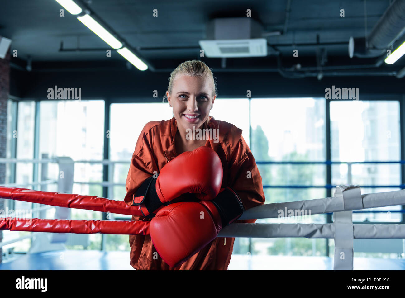 Smiling blue-eyed woman boxing in ring while training hard Stock Photo ...