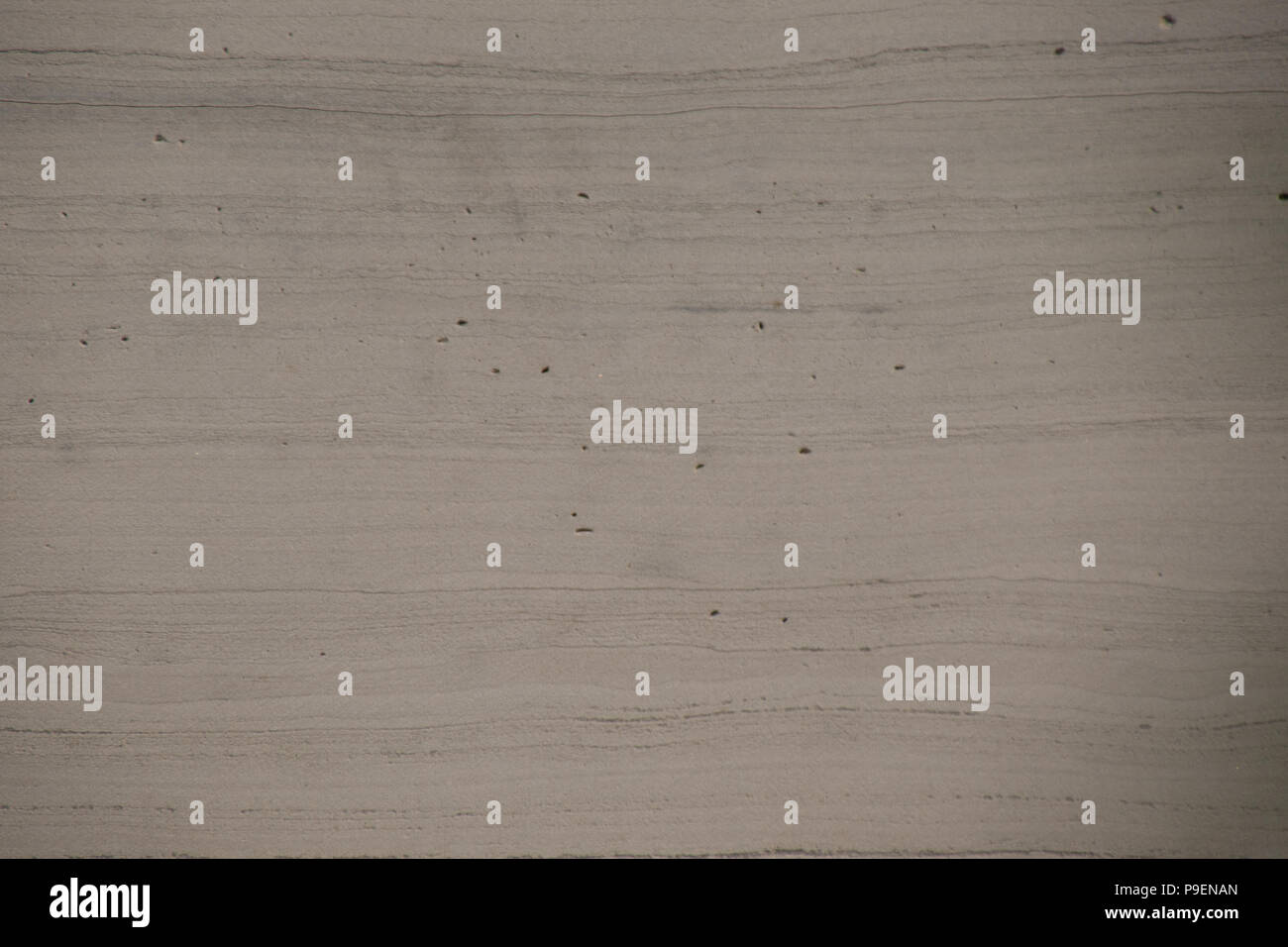 Closeup smooth cut limestone rock face. A pale beige lined wallpaper ...