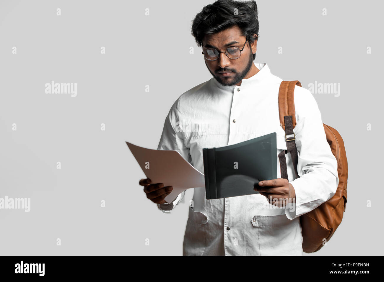cute indian student is looking at paper isolated on the white ...