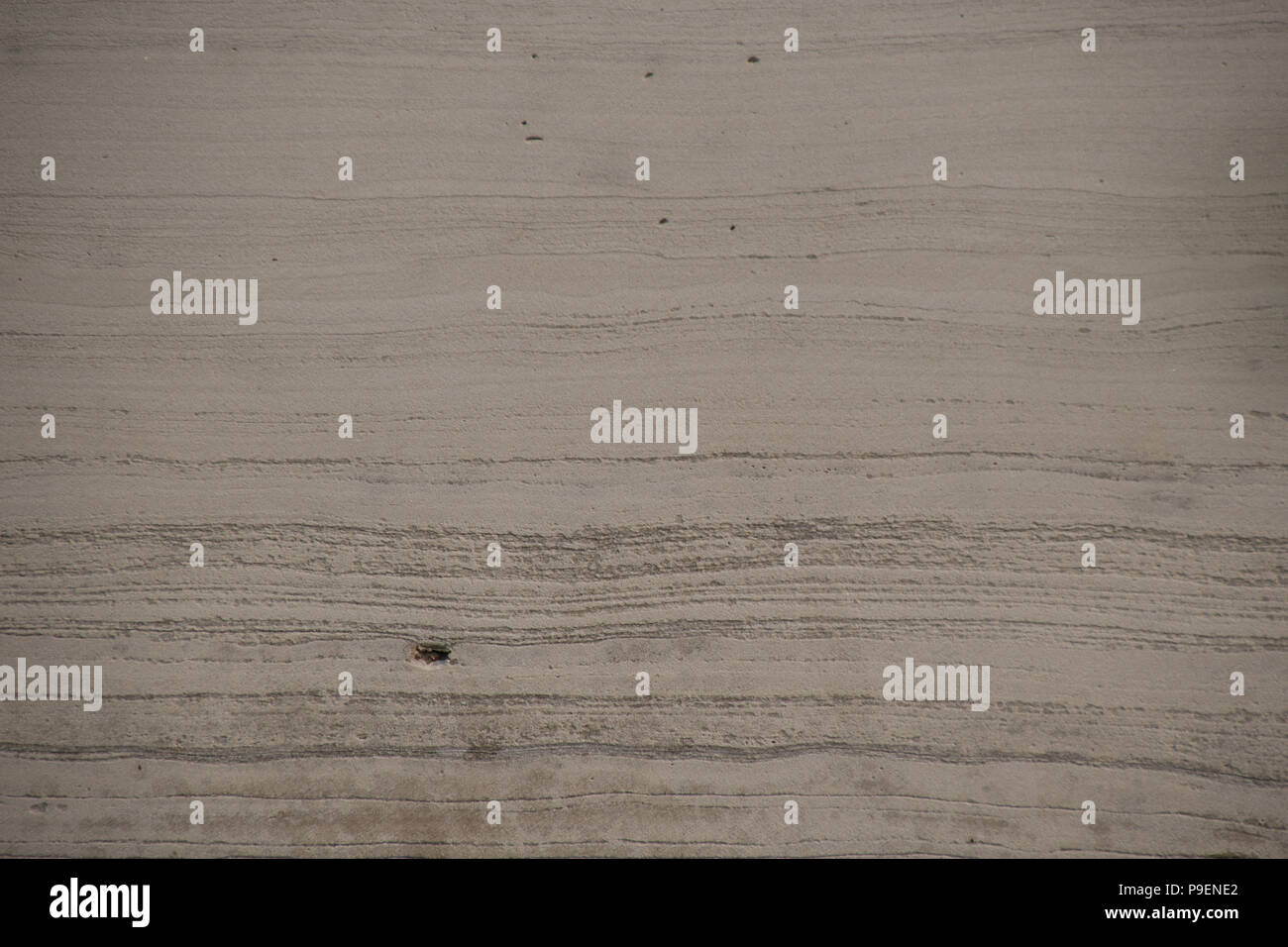 Closeup smooth cut limestone rock face. A pale beige lined wallpaper ...