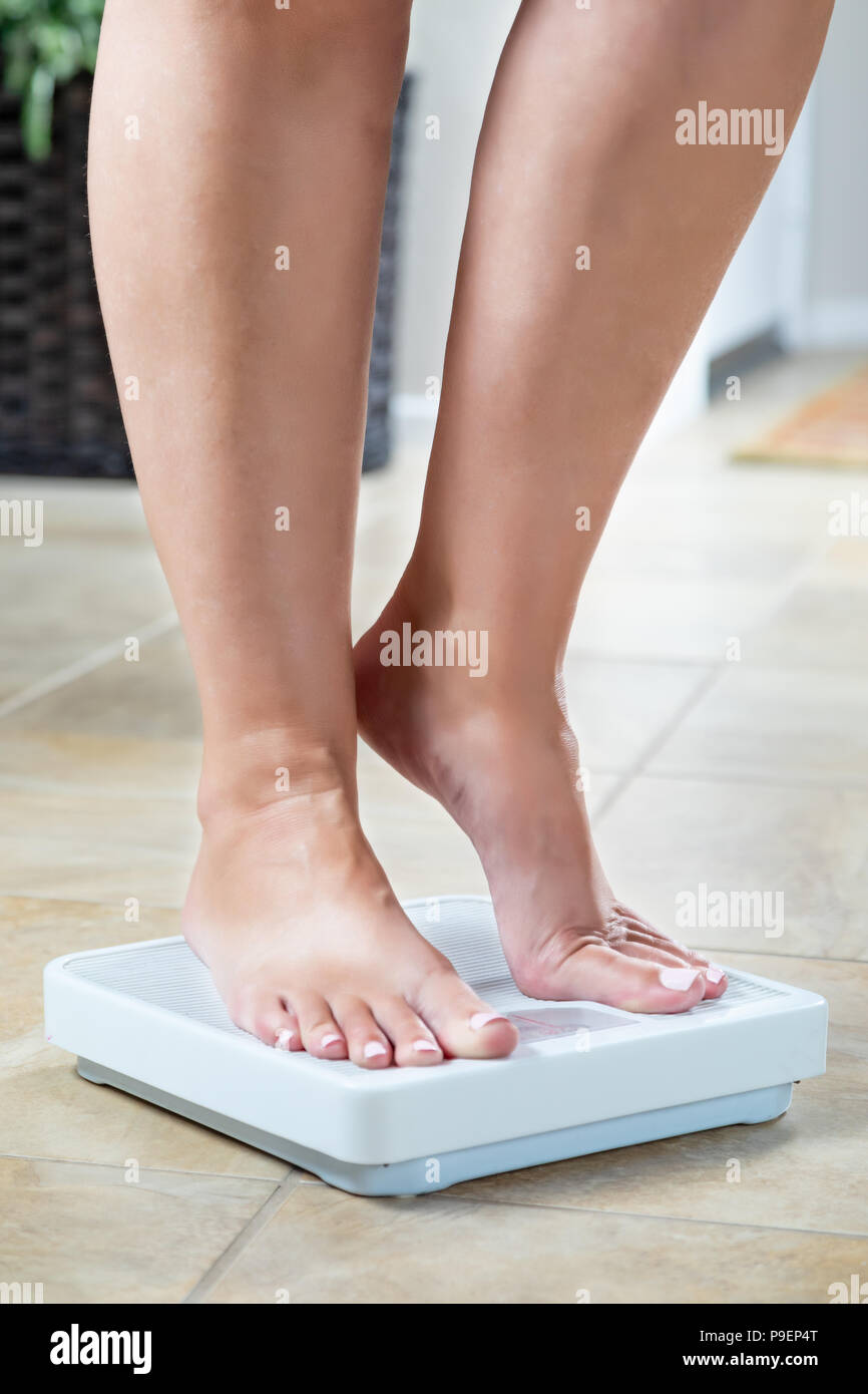 Woman Standing on Weight Scale At Home Stock Photo - Alamy