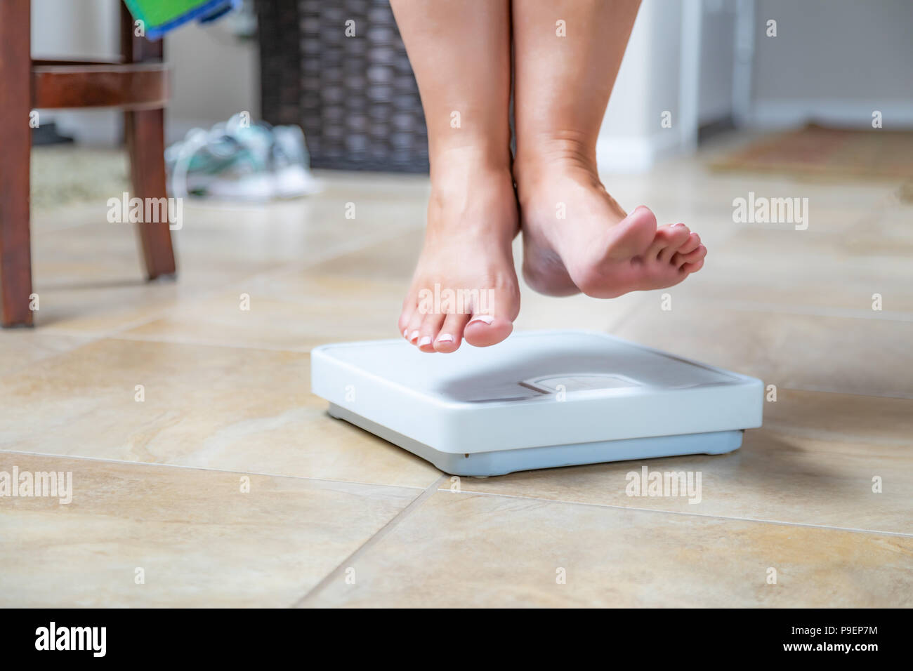 Woman Floating Slightly Above Sruface of Weight Scale Stock Photo - Alamy