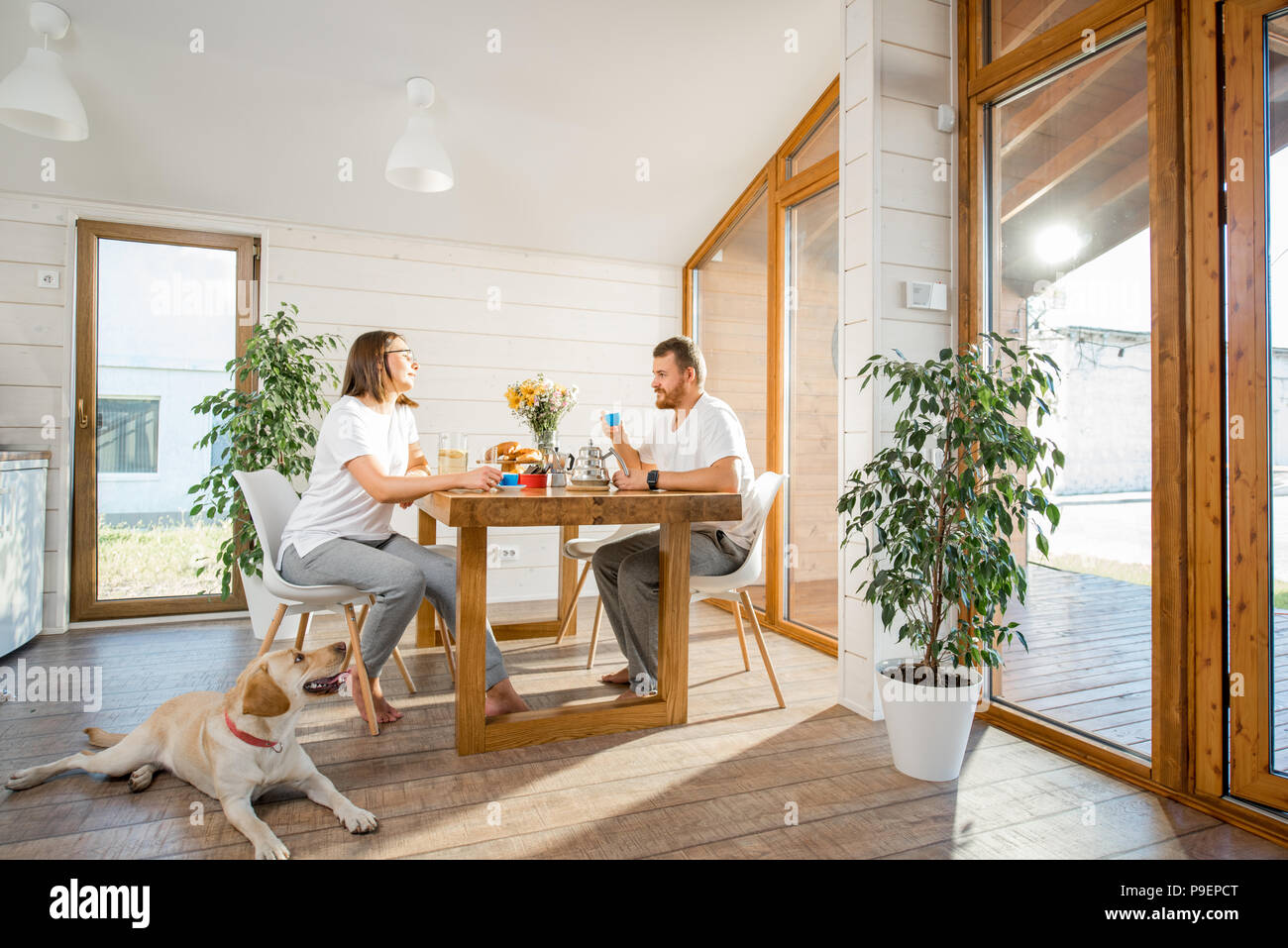 Couple with dog in the house Stock Photo - Alamy