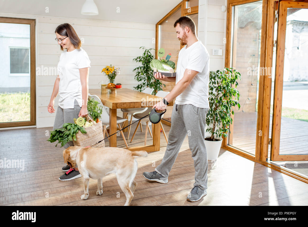 Couple coming home with dog and food Stock Photo - Alamy
