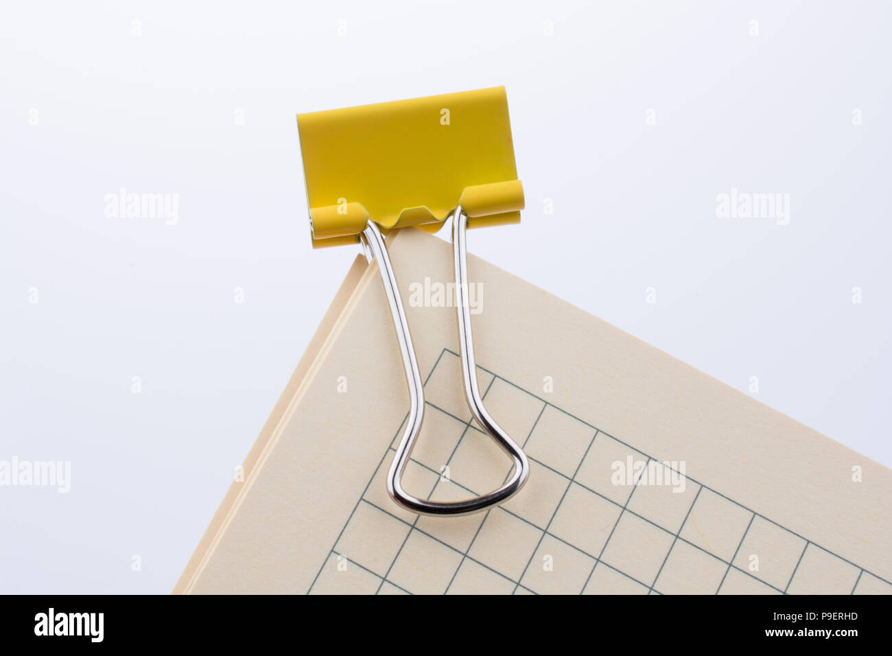 Colored paper clip on a checked notebook page Stock Photo - Alamy
