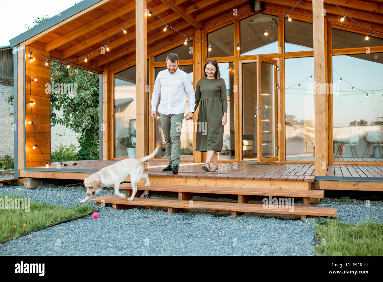 Couple with dog near the house Stock Photo - Alamy