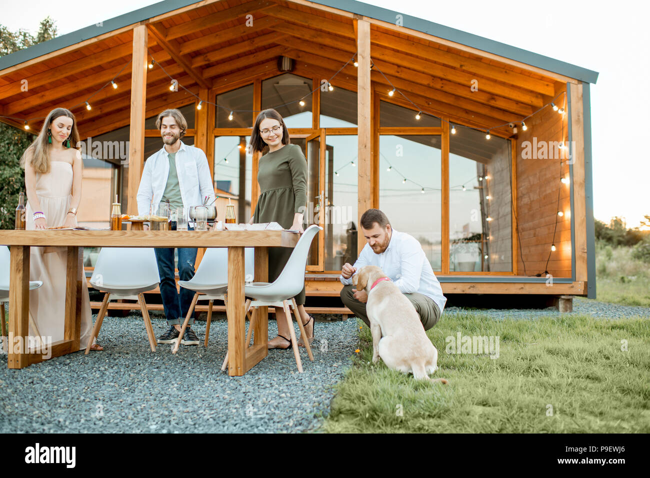 Friends with dog on the backyard of the house Stock Photo - Alamy