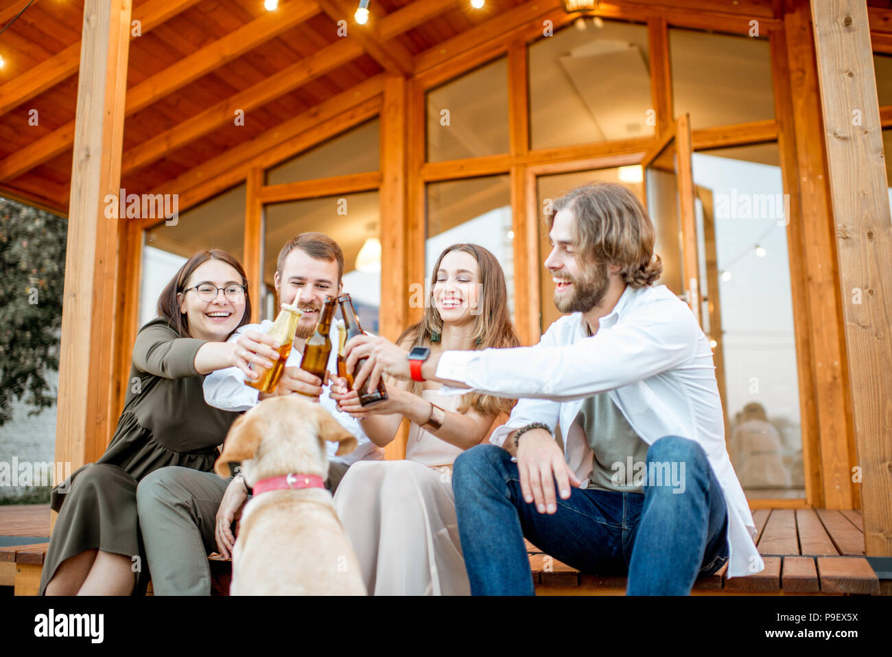Friends with dog in front of the house Stock Photo - Alamy