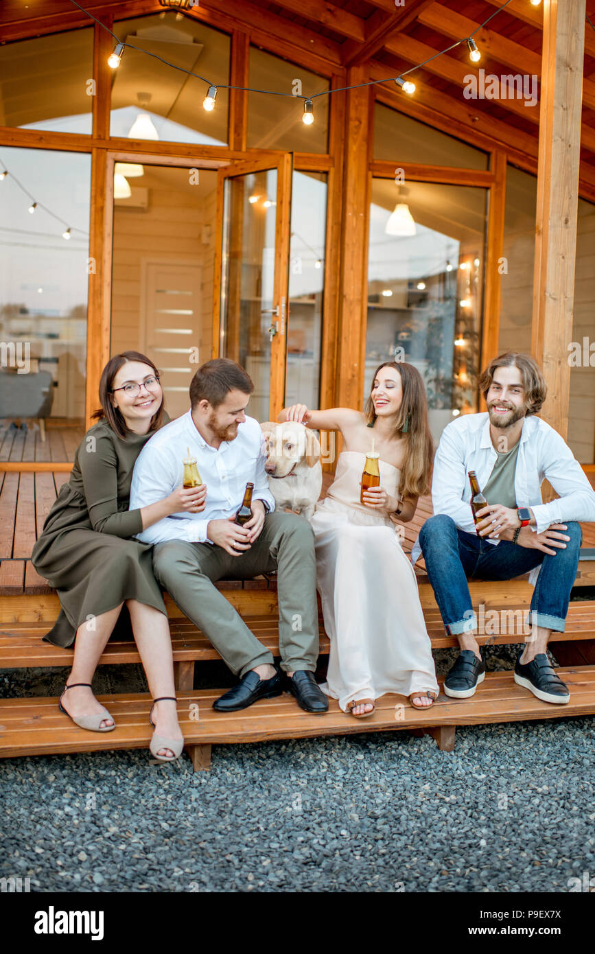 Friends with dog in front of the house Stock Photo - Alamy