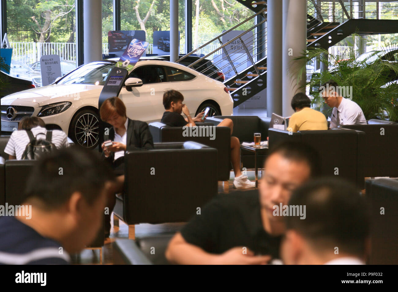 Guangzhou, China. 10th July, 2018. Car salesmen advise customers at a ...