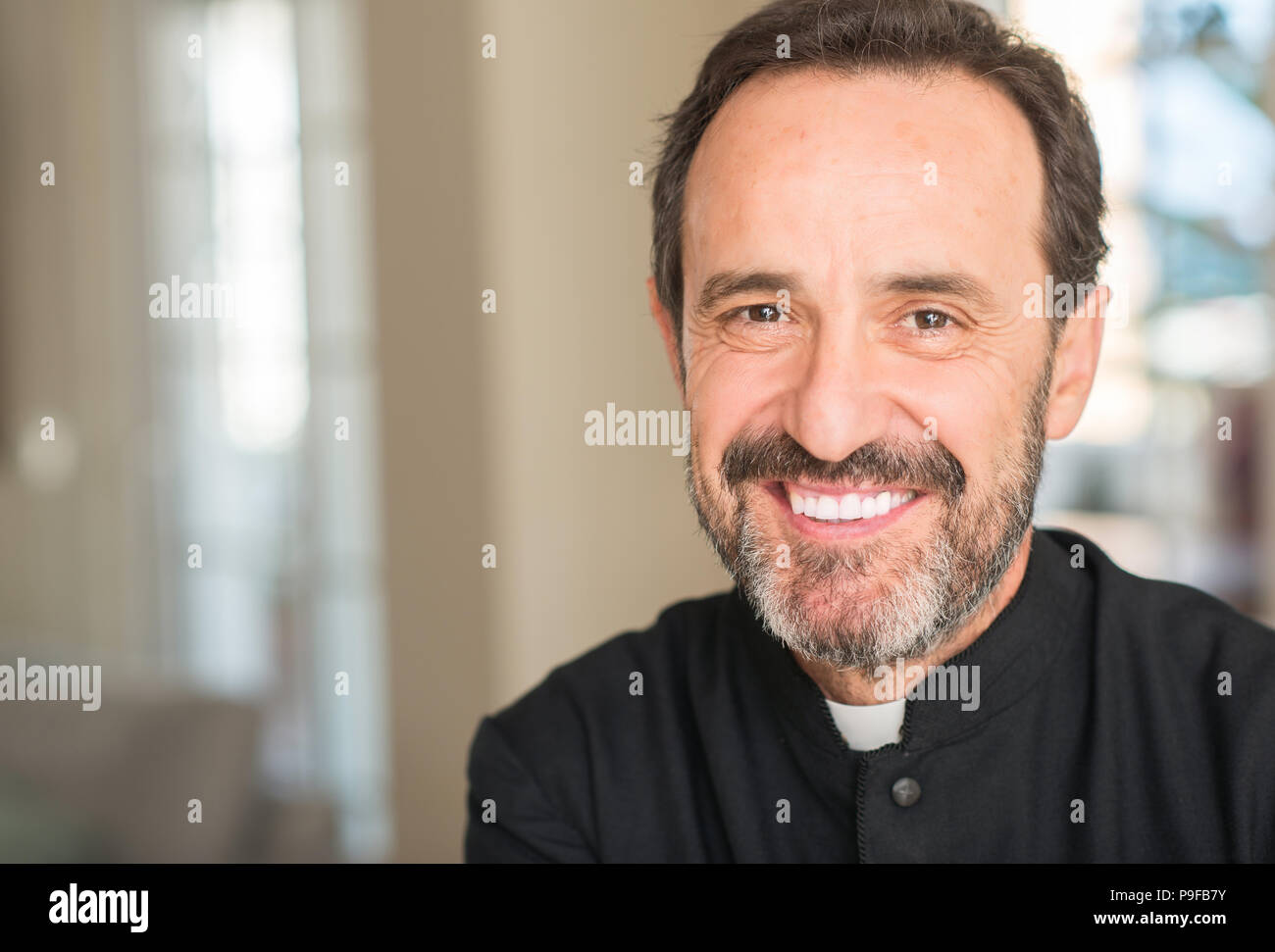 Christian priest man with a happy face standing and smiling with a ...