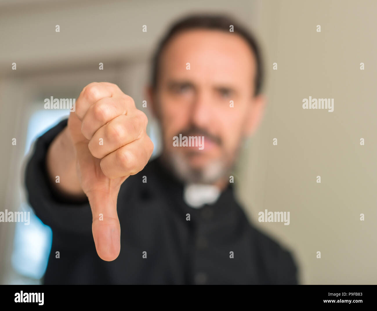Christian priest man with angry face, negative sign showing dislike ...