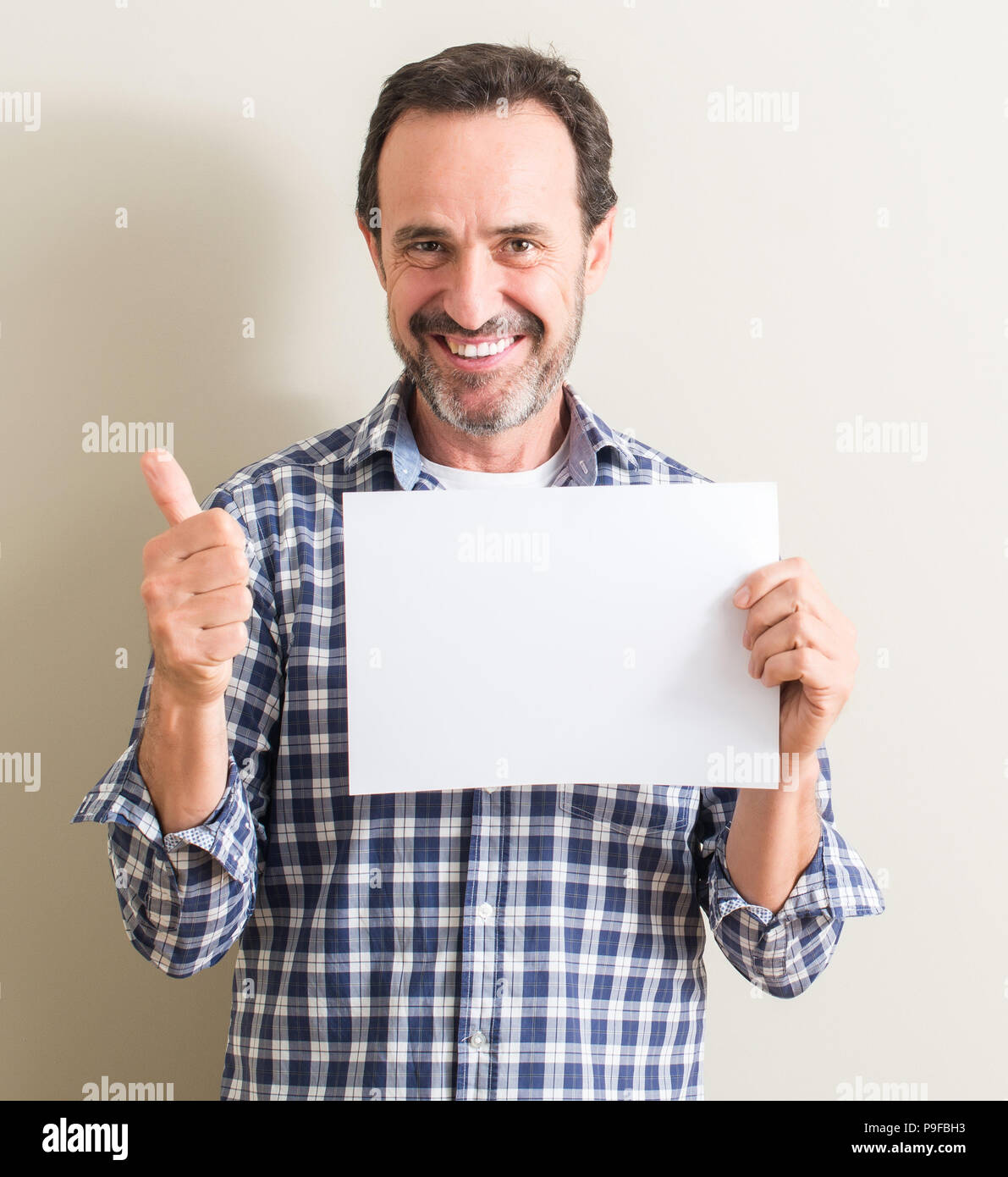 Senior man holding blank paper sheet happy with big smile doing ok sign ...