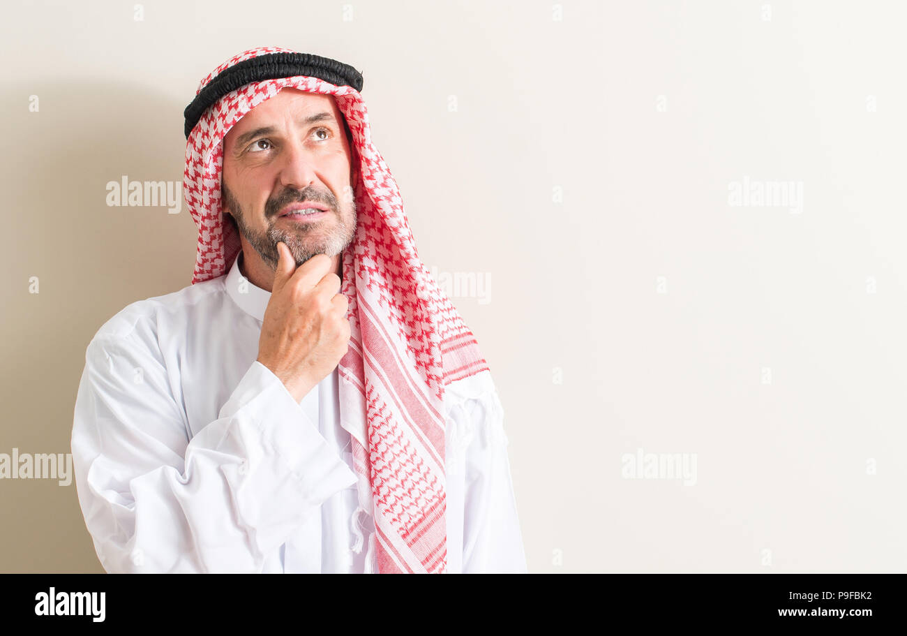 Senior arabic man serious face thinking about question, very confused ...