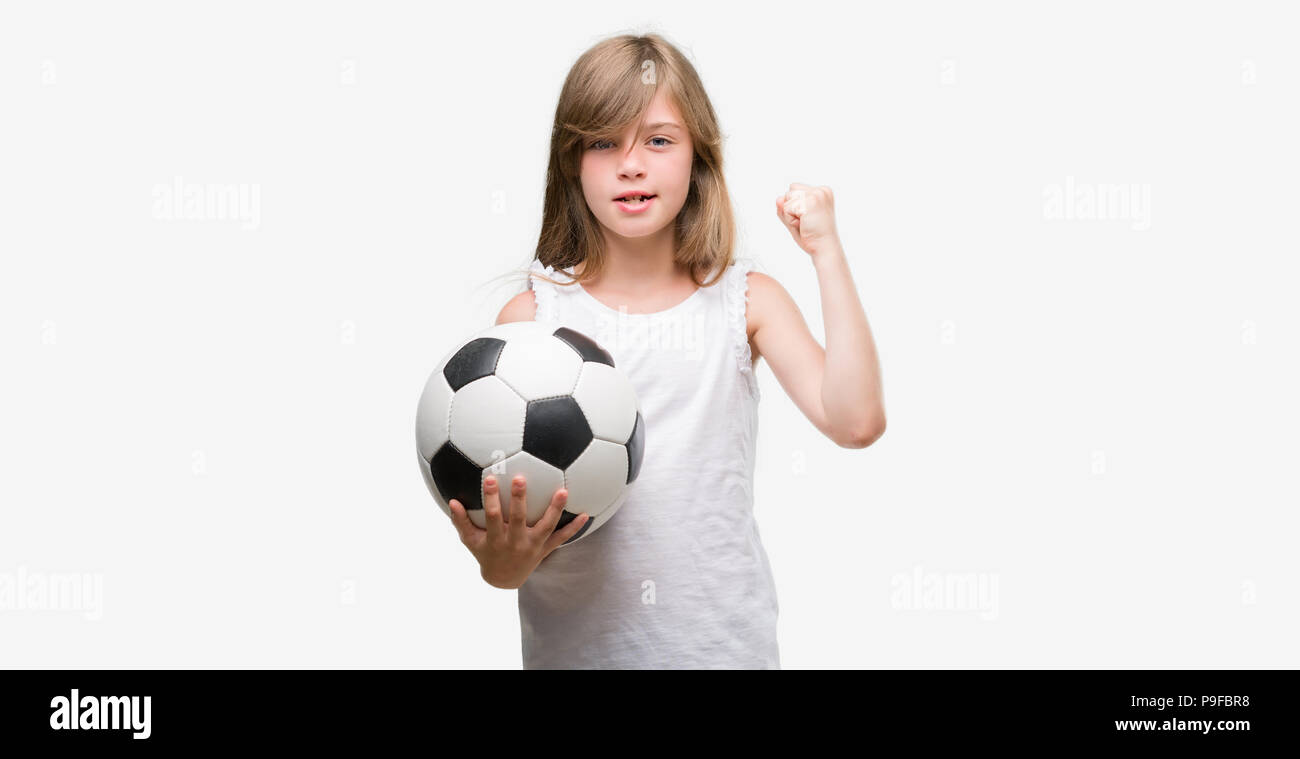 Young blonde toddler holding football ball annoyed and frustrated ...