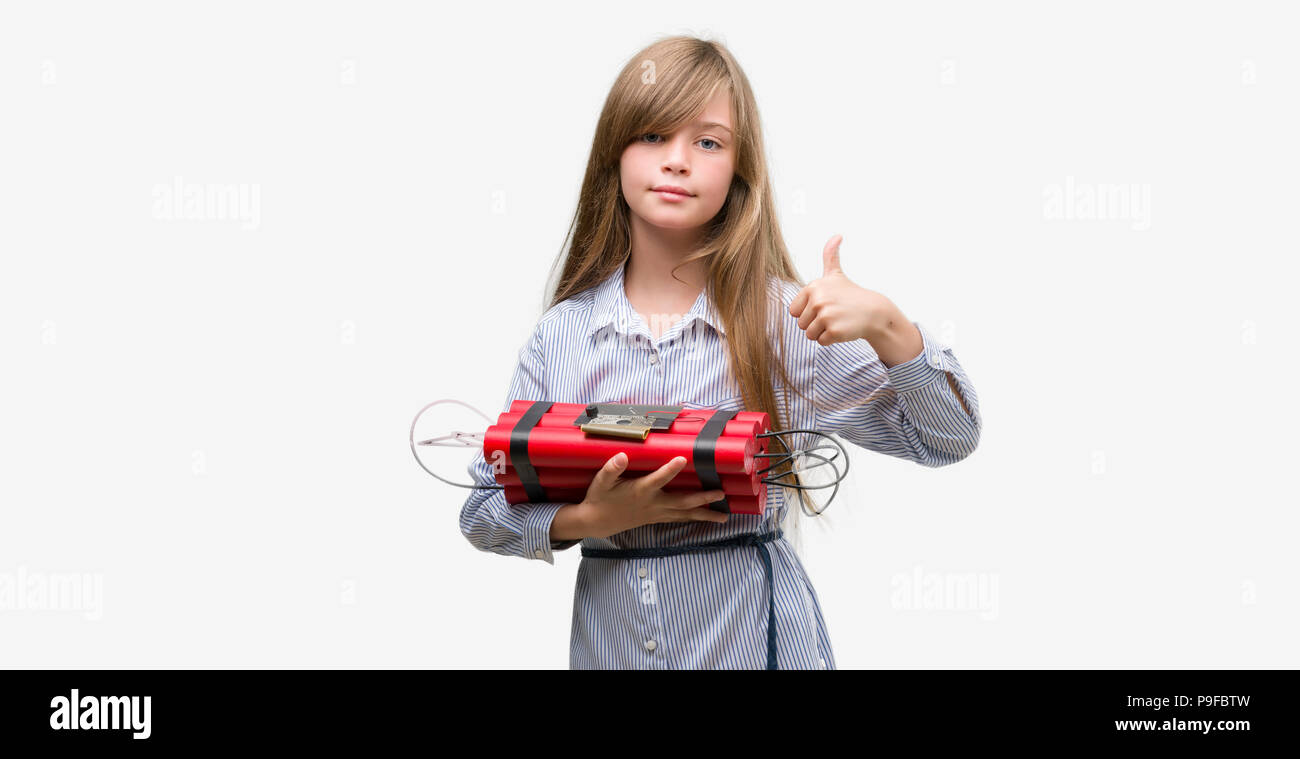 Young blonde child holding dynamite bomb happy with big smile doing ok ...