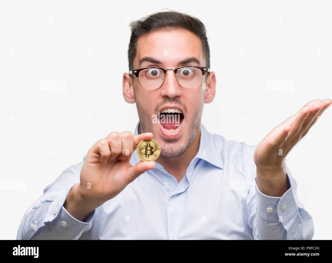 Handsome young man holding bitcoin very happy and excited, winner ...