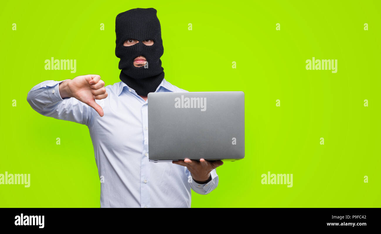 Business hacker man holding a computer laptop with angry face, negative ...
