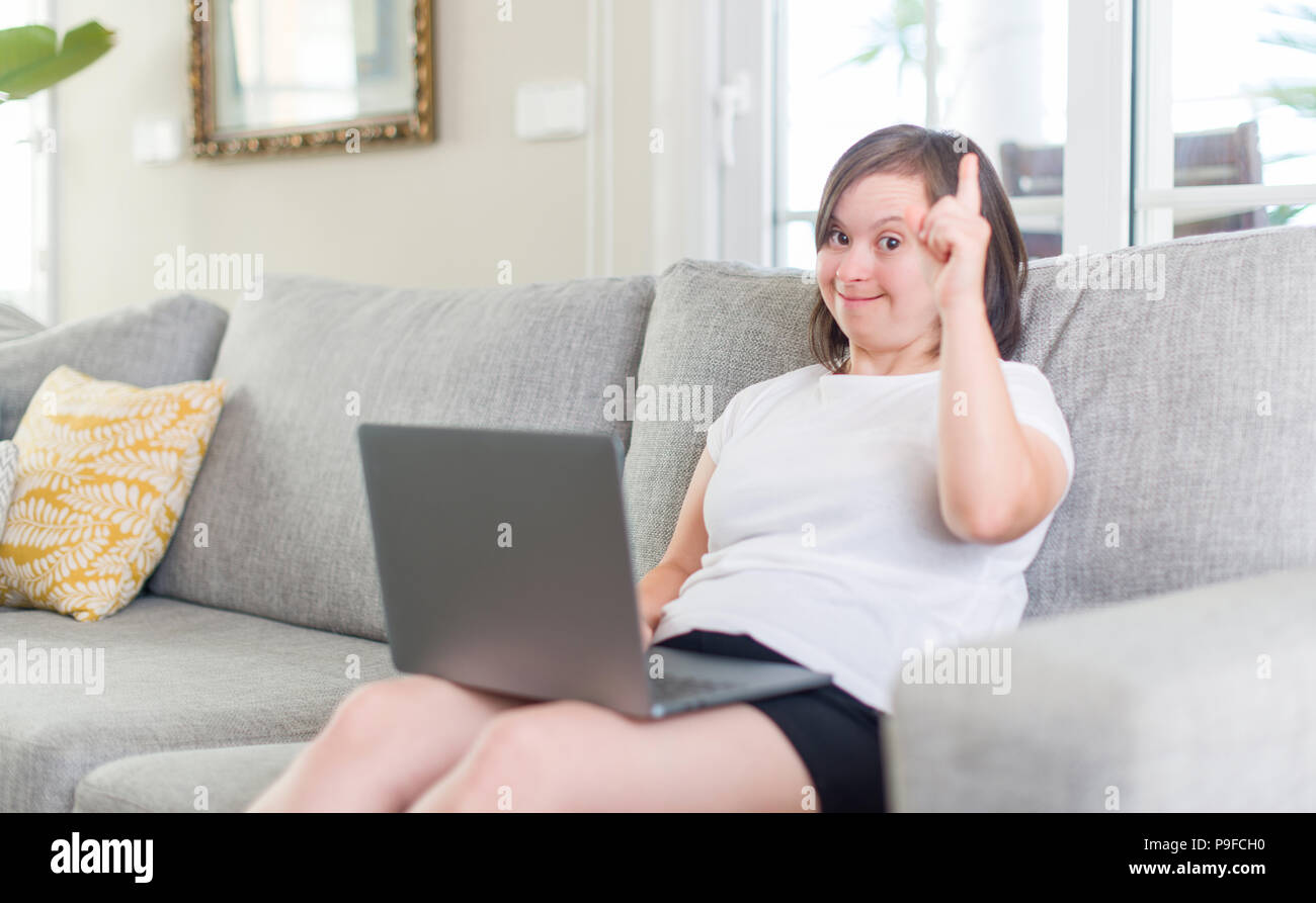 Down syndrome woman at home using computer laptop surprised with an ...