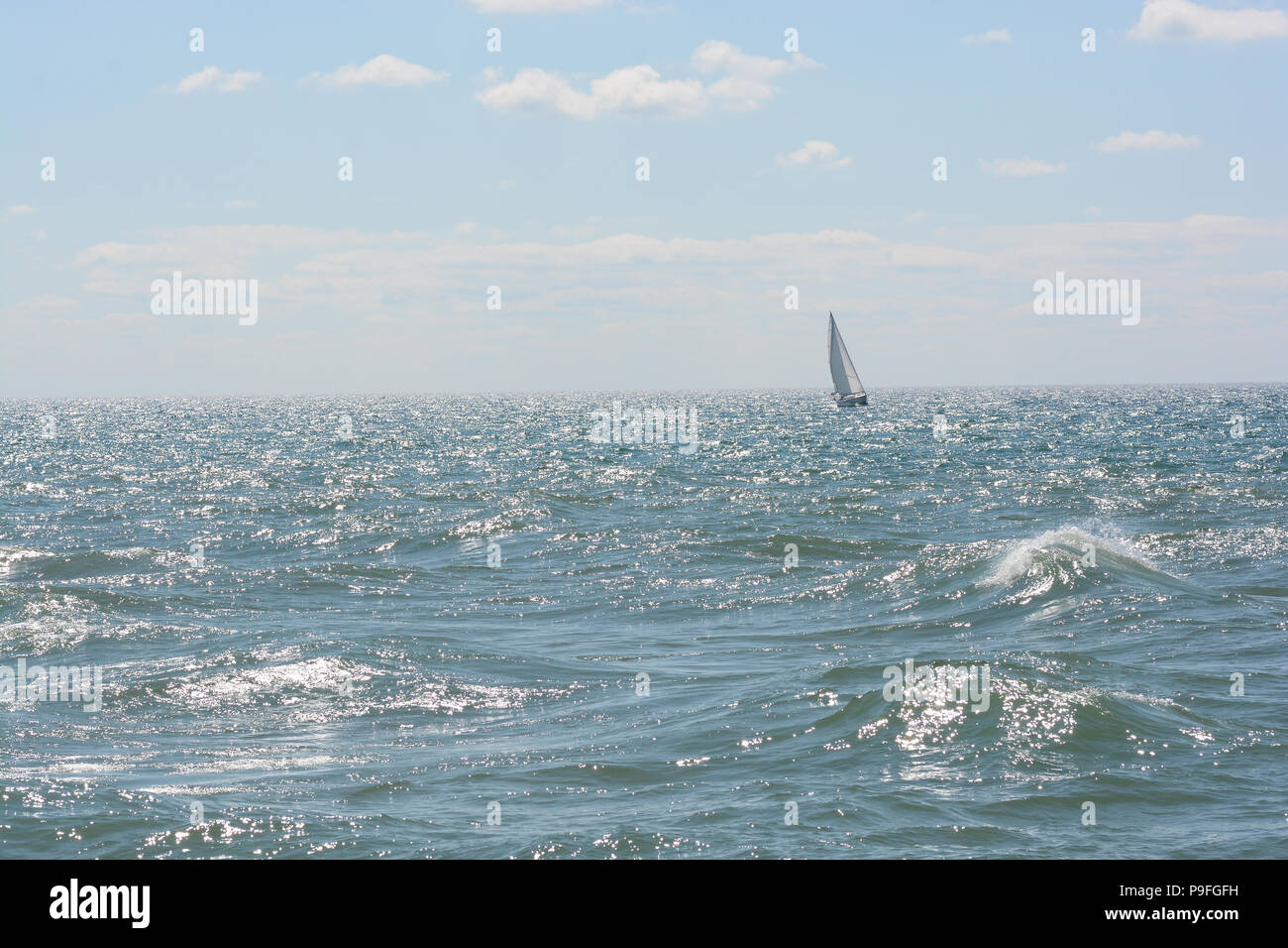 Sailing ship in the distance on the water. Waves, blue skies, breeze ...
