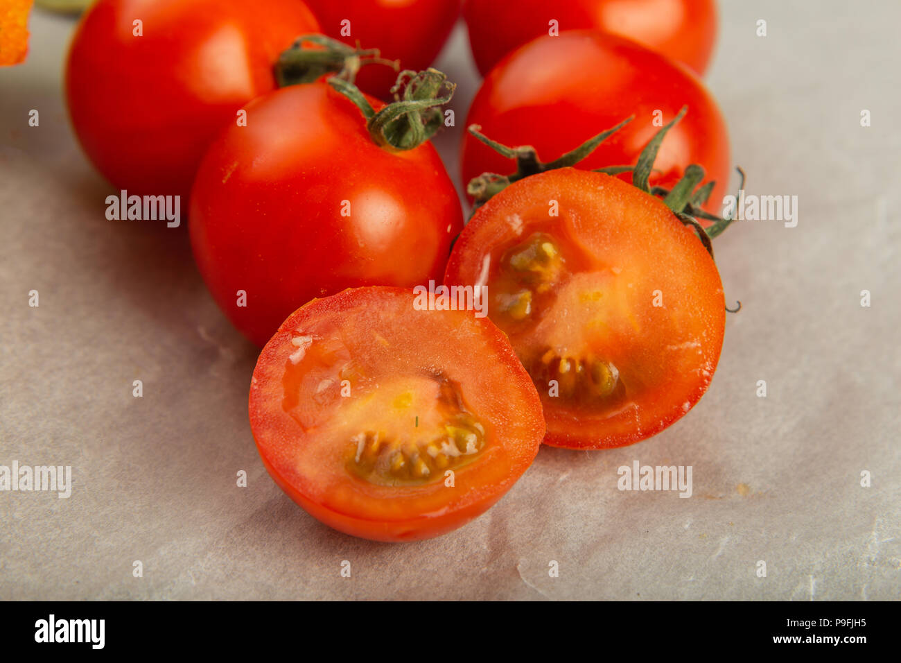 Tomatoes on baking paper, cut in half Stock Photo - Alamy