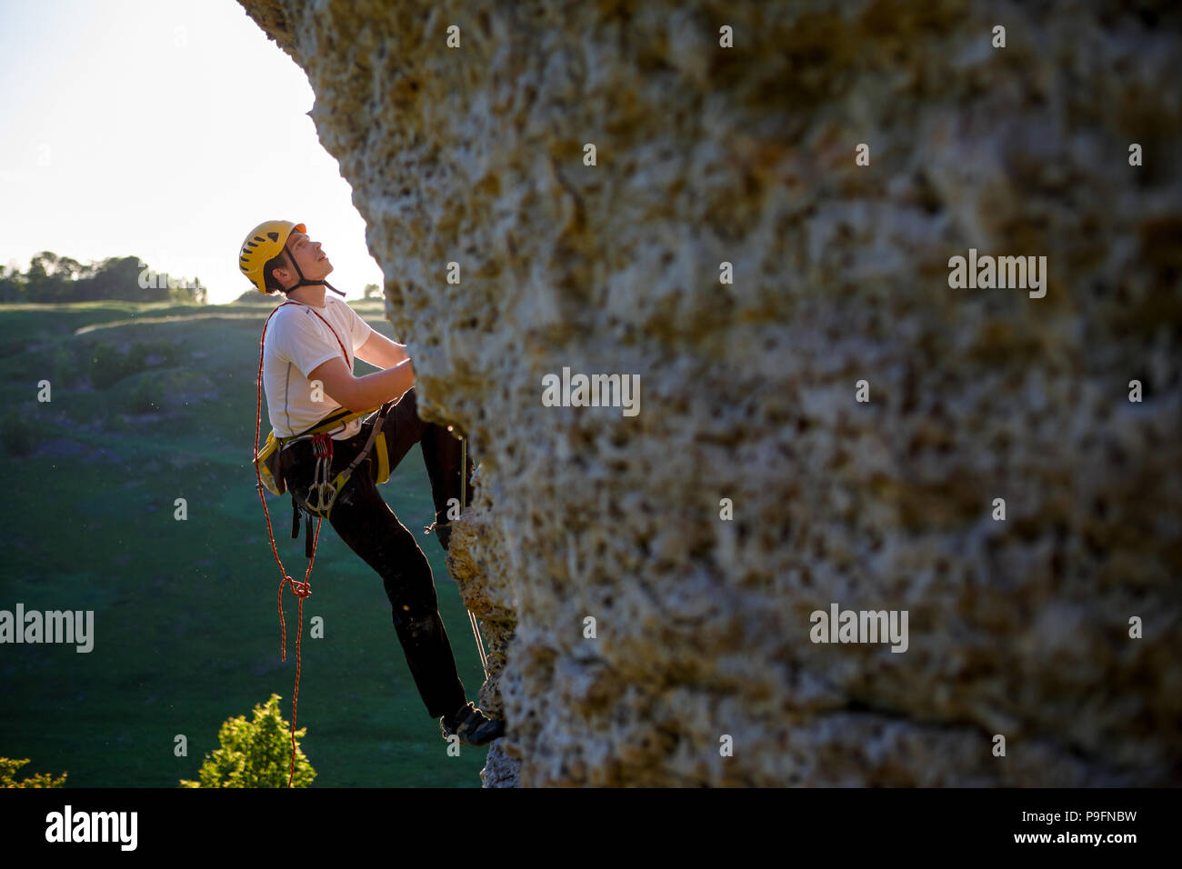 Image of tourist man in helmet clambering up Stock Photo - Alamy