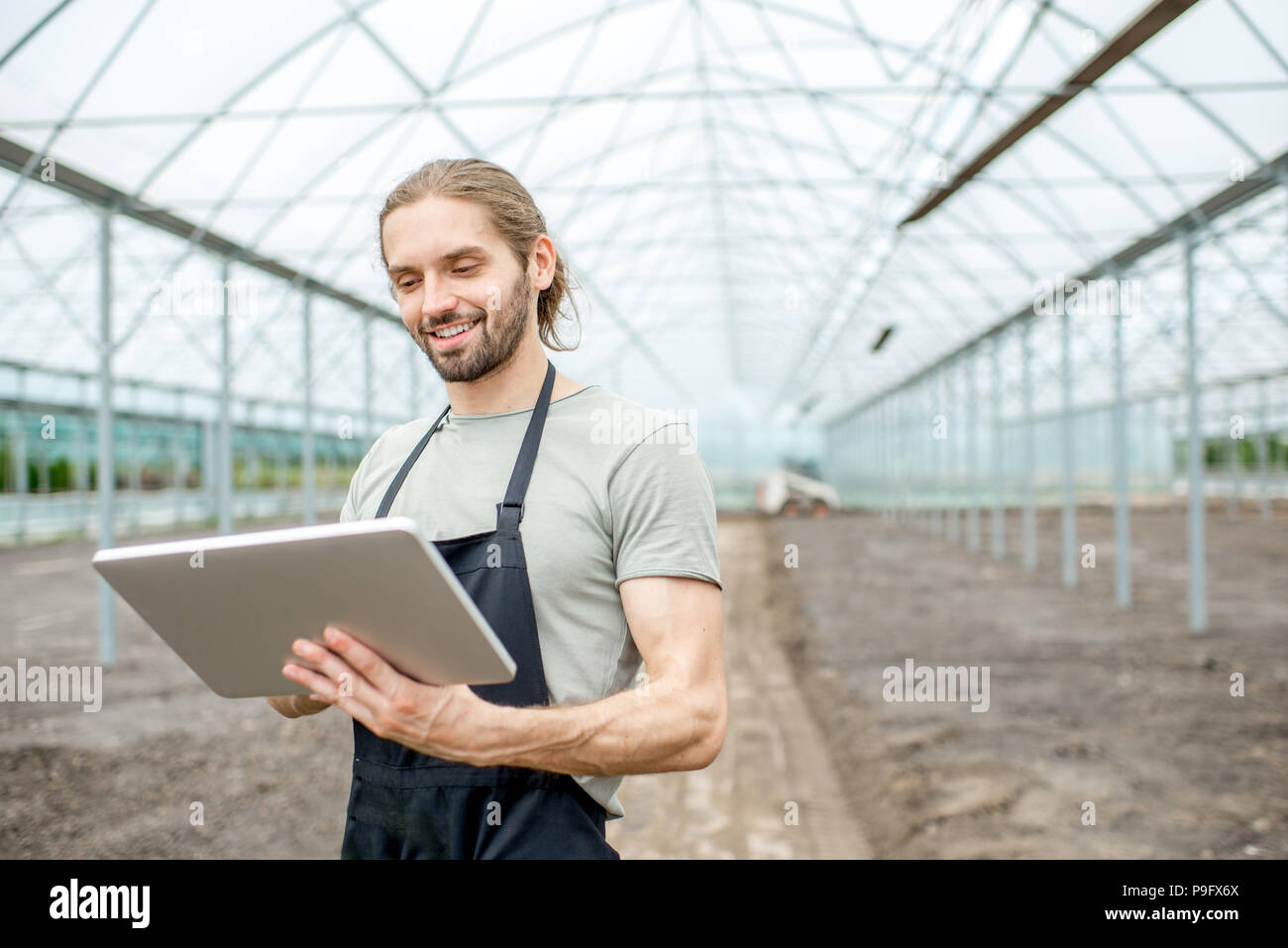 Farmer with tablet in the glasshouse Stock Photo - Alamy
