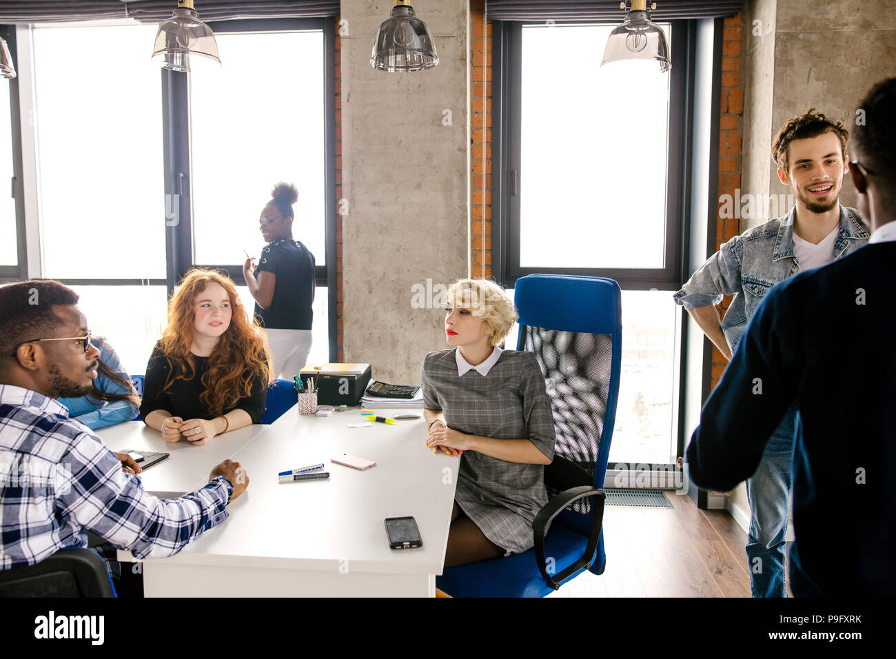serious strict blond office worker in dress sitting at her workplace ...