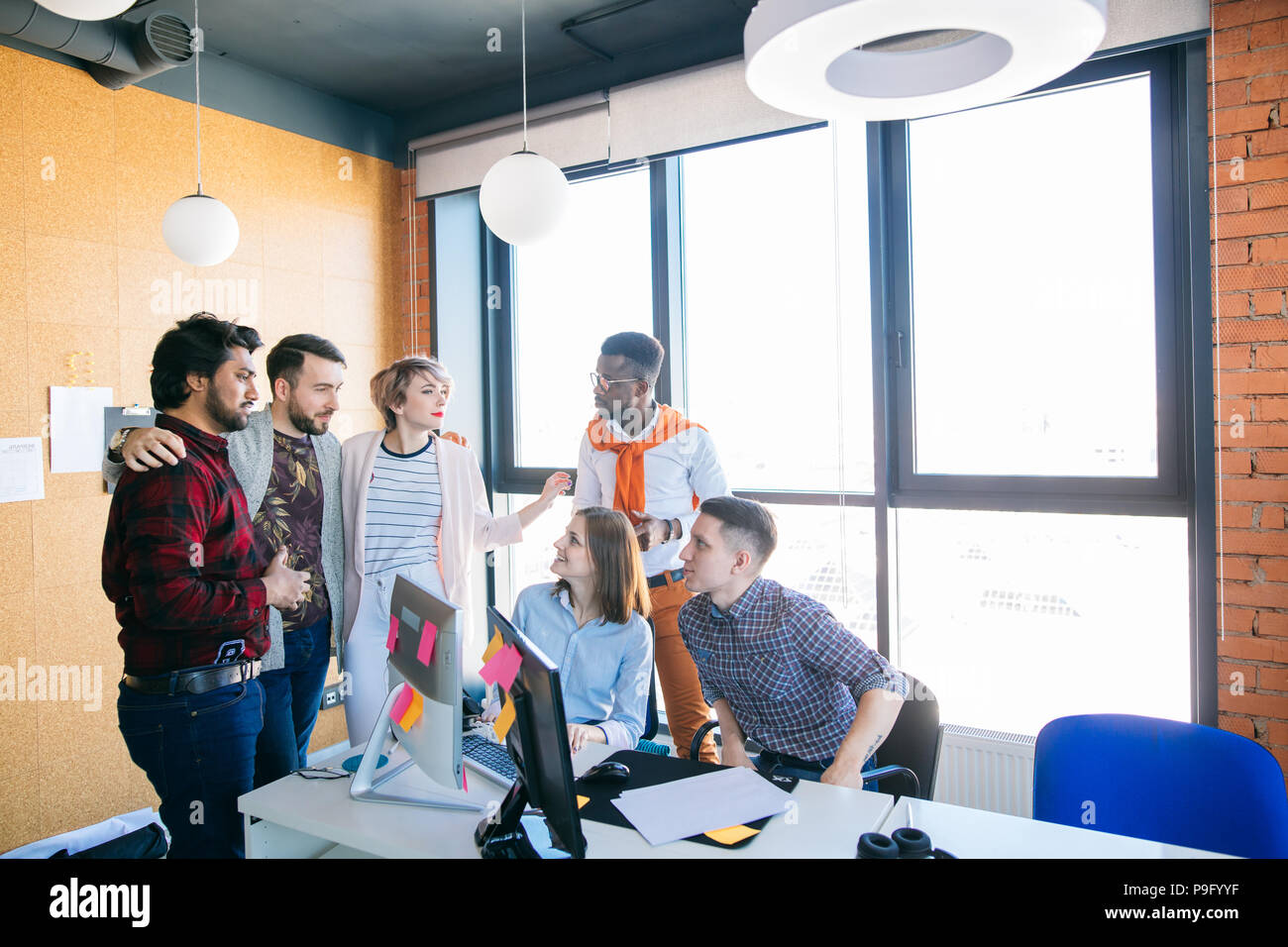 young programmers are gathered together and having a pleasant ...