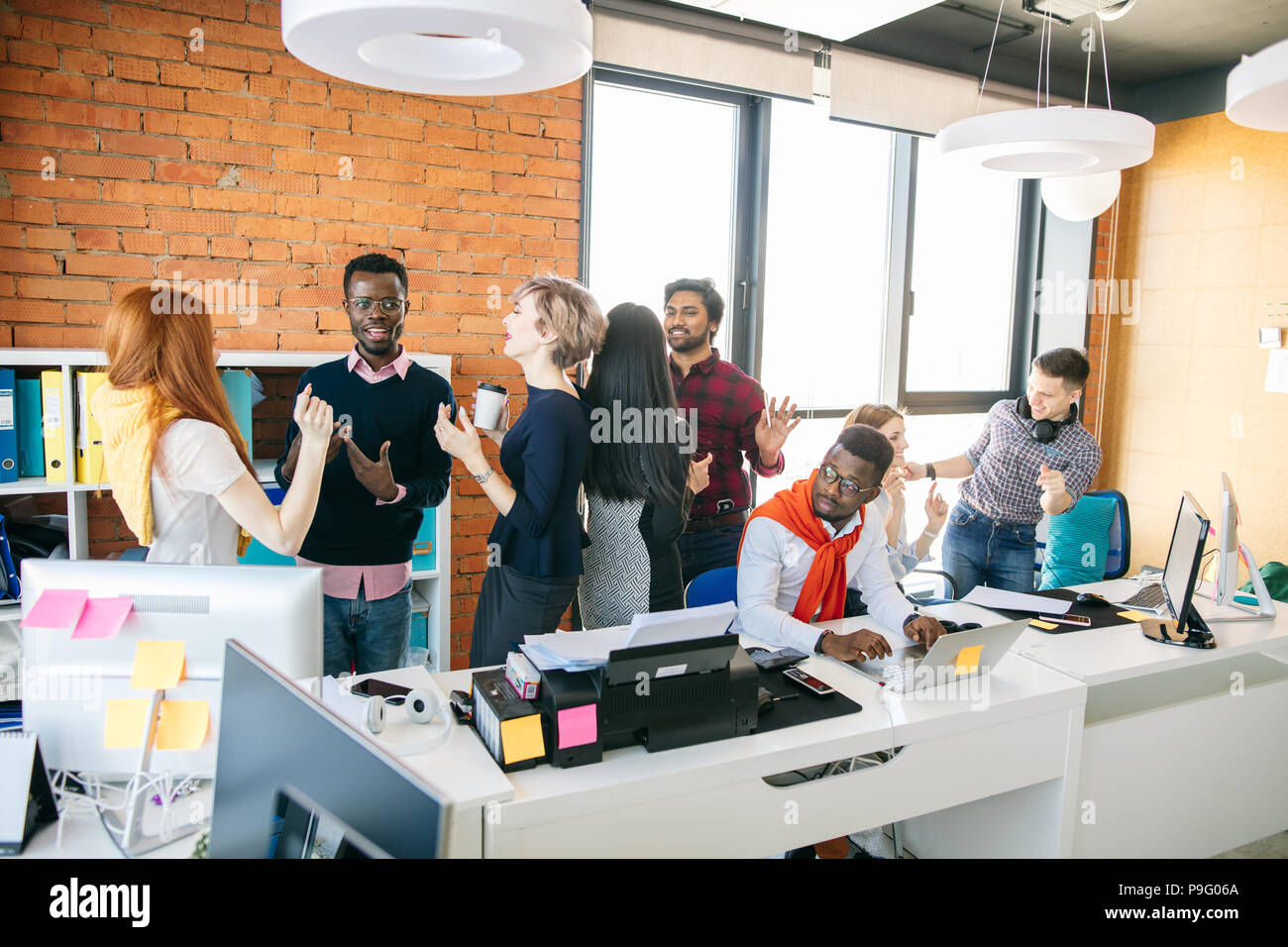 sad African guy cannot work on laptop because of noisy colleagues in ...