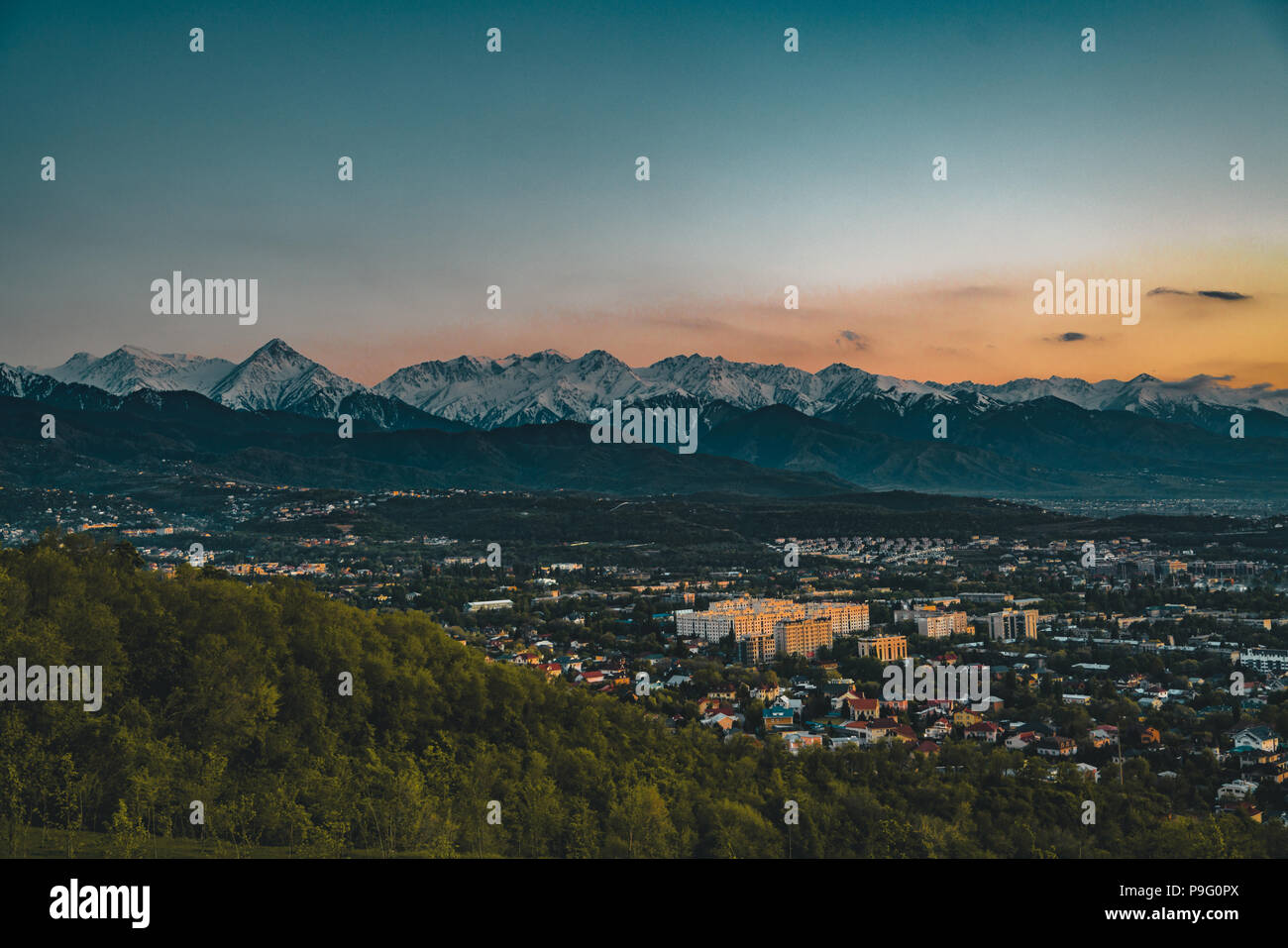 Sunset over the city of Almaty and a view of the Kok Tobe TV Tower ...