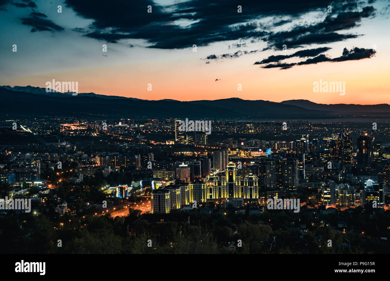 Sunset over the city of Almaty and a view of the Kok Tobe TV Tower ...