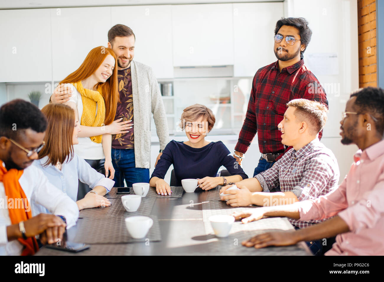 laughing business people telling jokes while drinking tea in the office ...