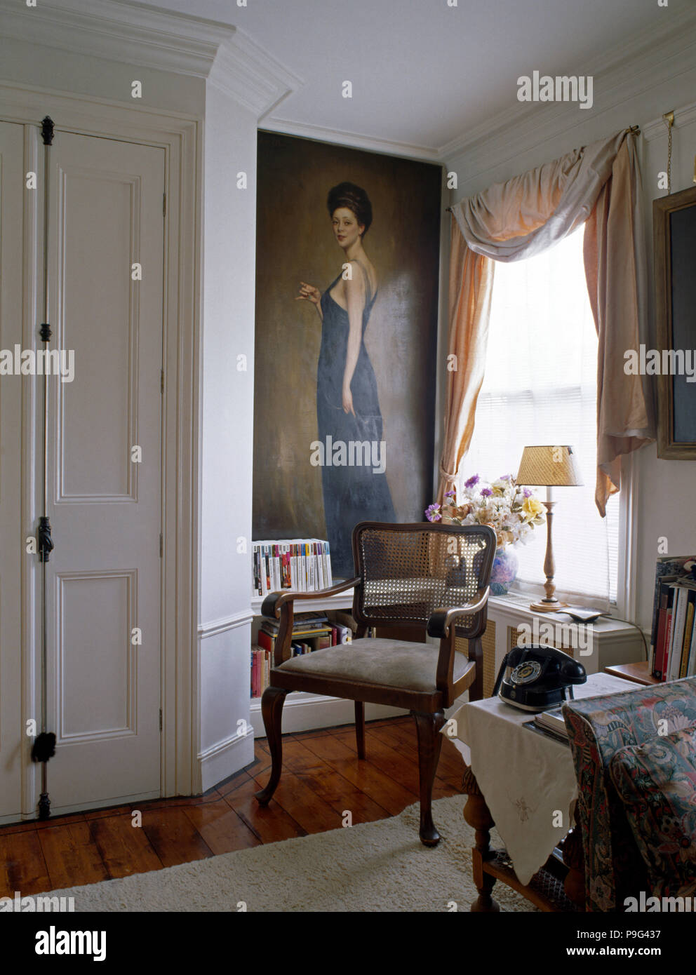 Large portrait on wall beside window with cream drapes in a townhouse ...