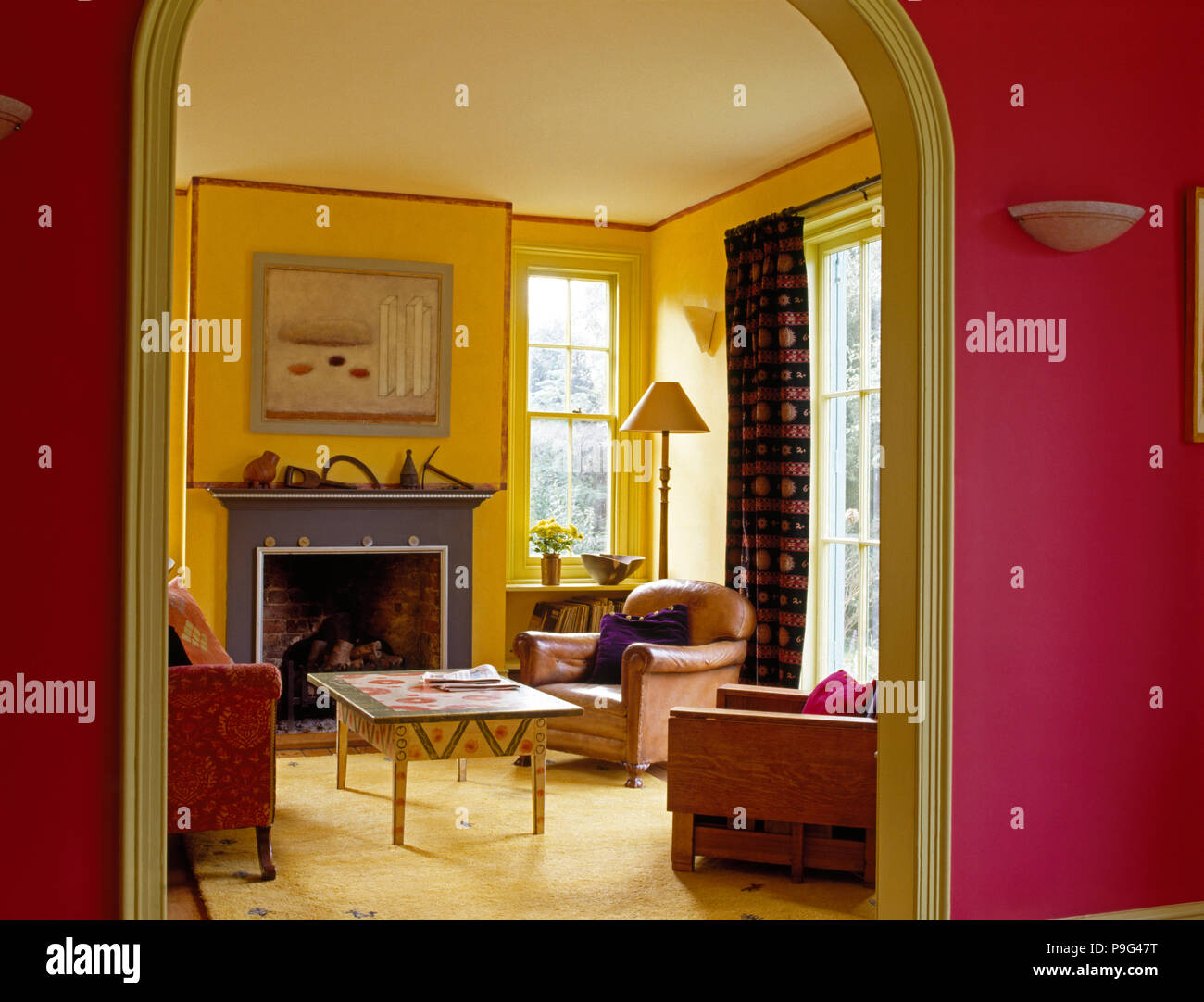 Bright pink hall with arched doorway to yellow living room Stock Photo ...